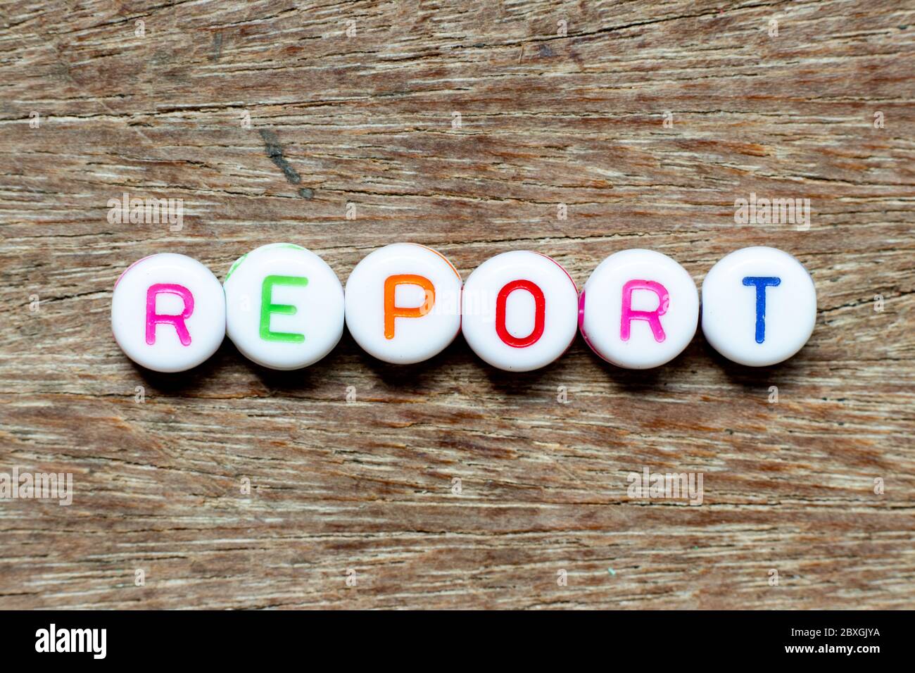 White bead with color letter in word report on wood background Stock ...