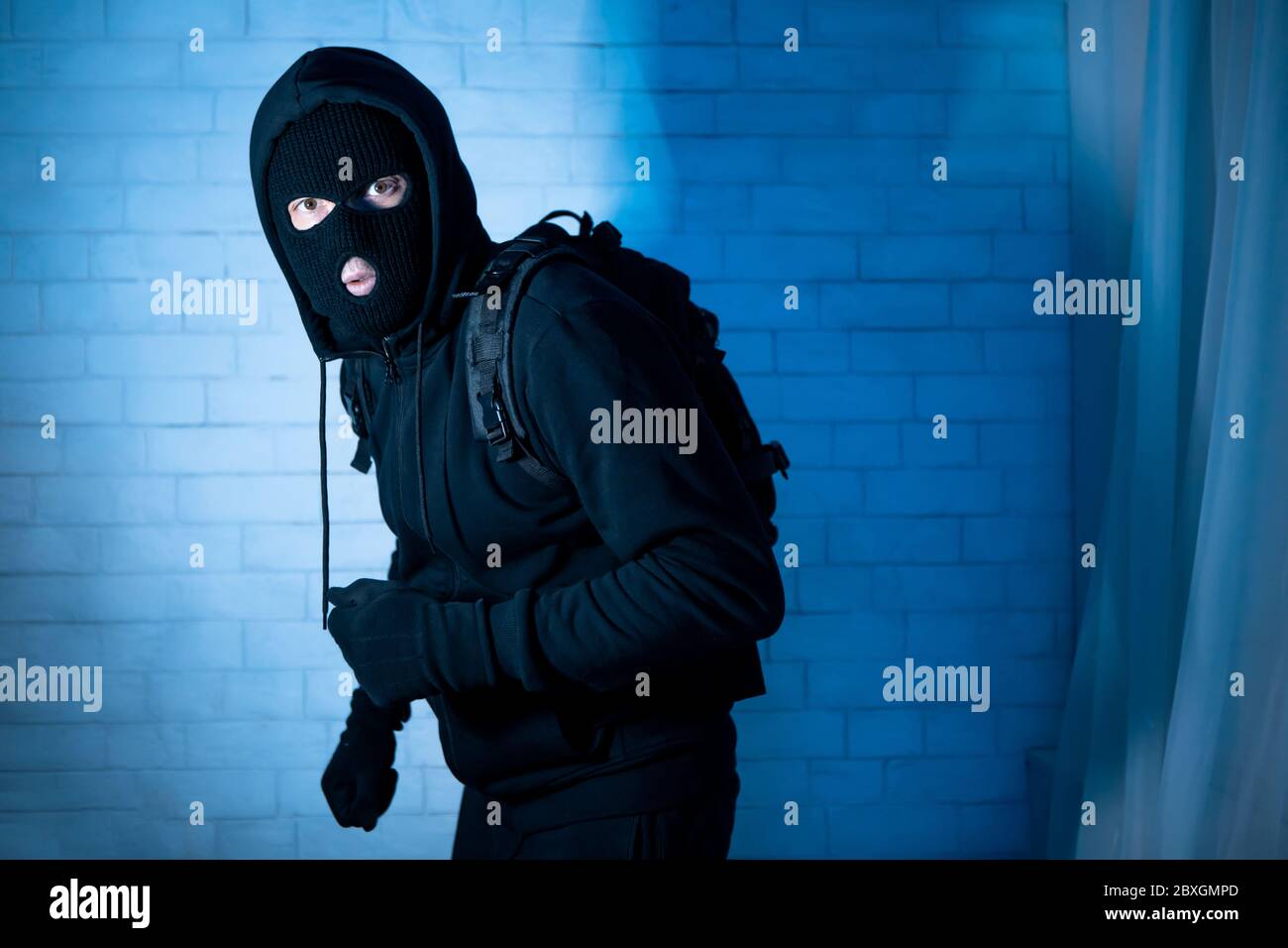 Sneaky robber ready to steal something at home Stock Photo - Alamy