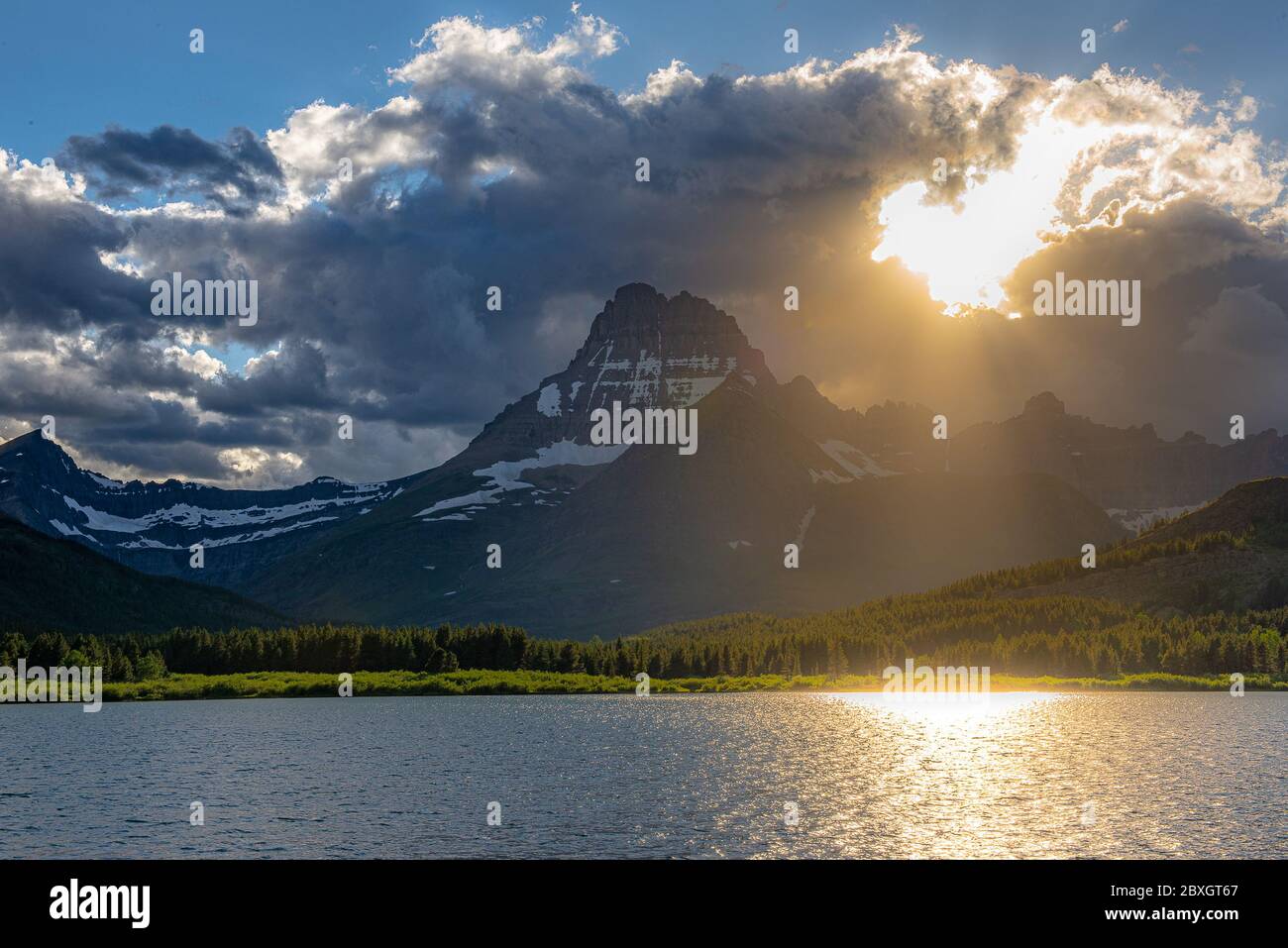 Beautiful sunset over the mountain range and Swiftcurrent lake at ...