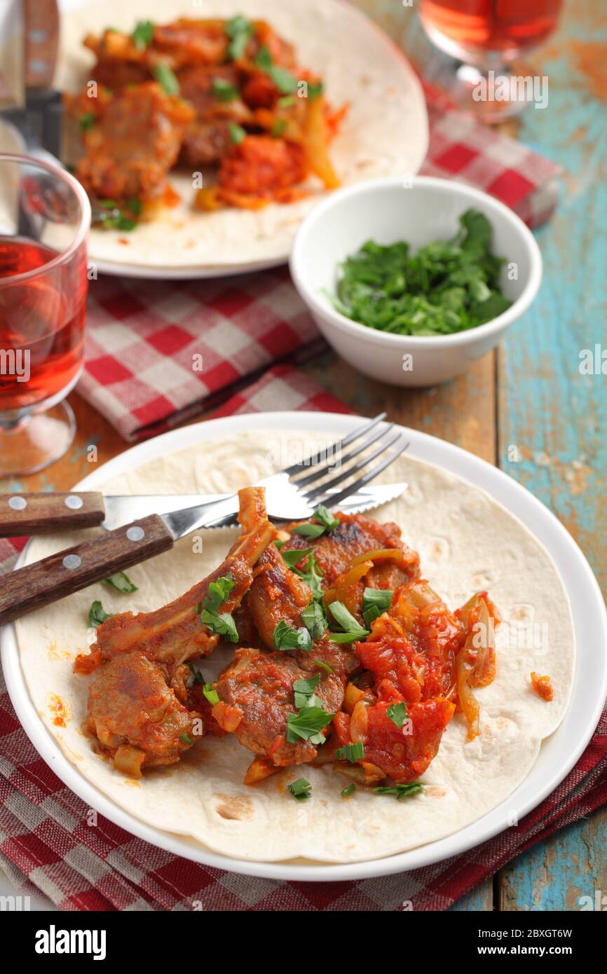 Roasted lamb chops with tomato and pepper on a rustic table Stock Photo ...