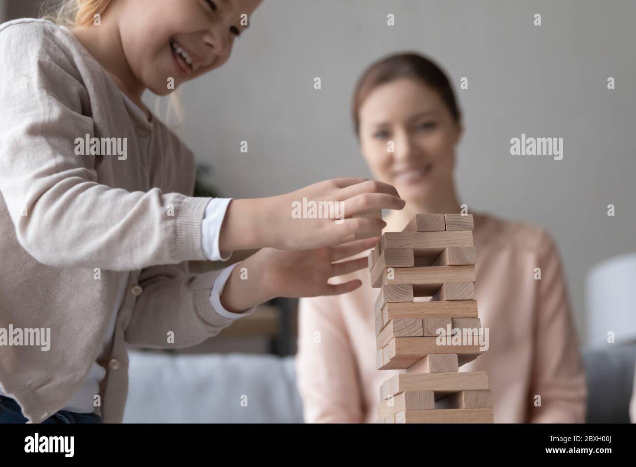 Little girl play stack and crash game with mom Stock Photo - Alamy