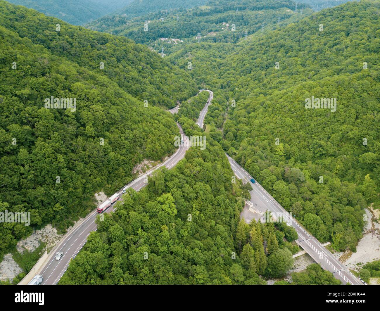 Aerial top down view: of cars driving on zig zag winding mountain road ...