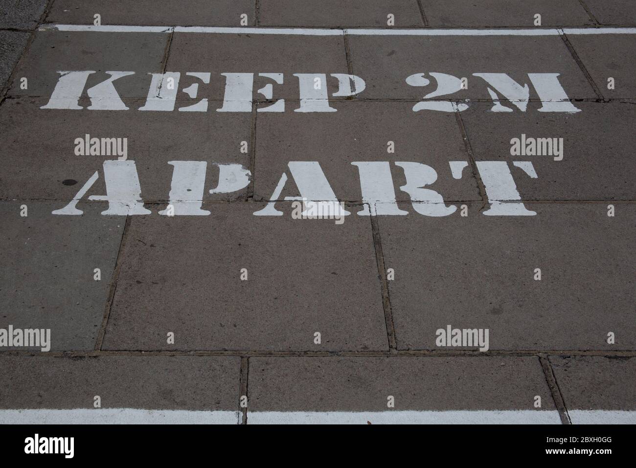 Sign on the pavement reminding people to stay two metres apart during ...
