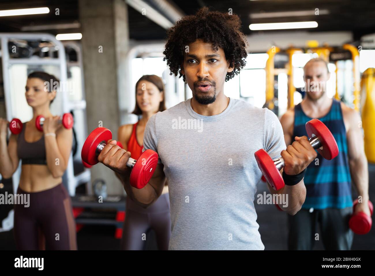 Group of young people doing exercises in gym Stock Photo - Alamy