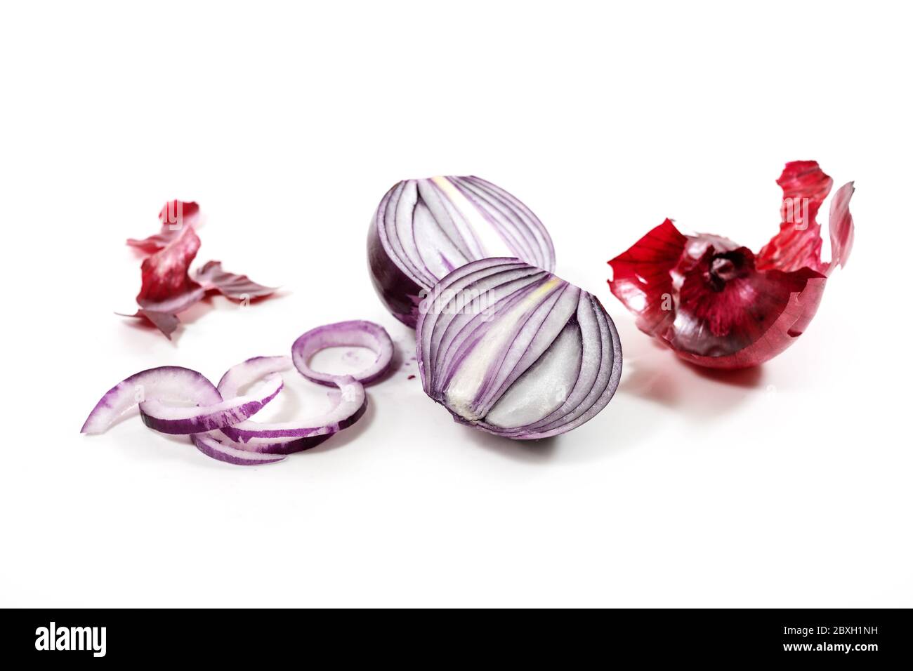 Fresh peeled red onion cut in half and slices isolated with small ...