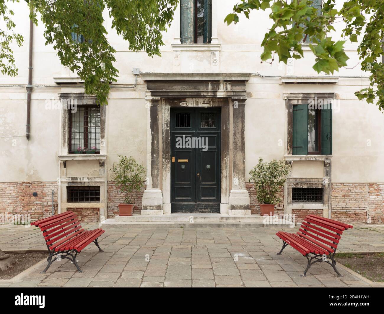 Red benches and building facade, Venice, Italy Stock Photo - Alamy
