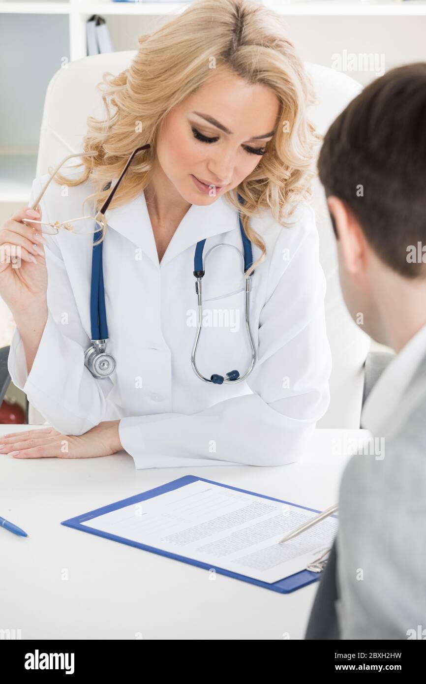 Female doctor and patient reading contract at pad. Physical agreement ...