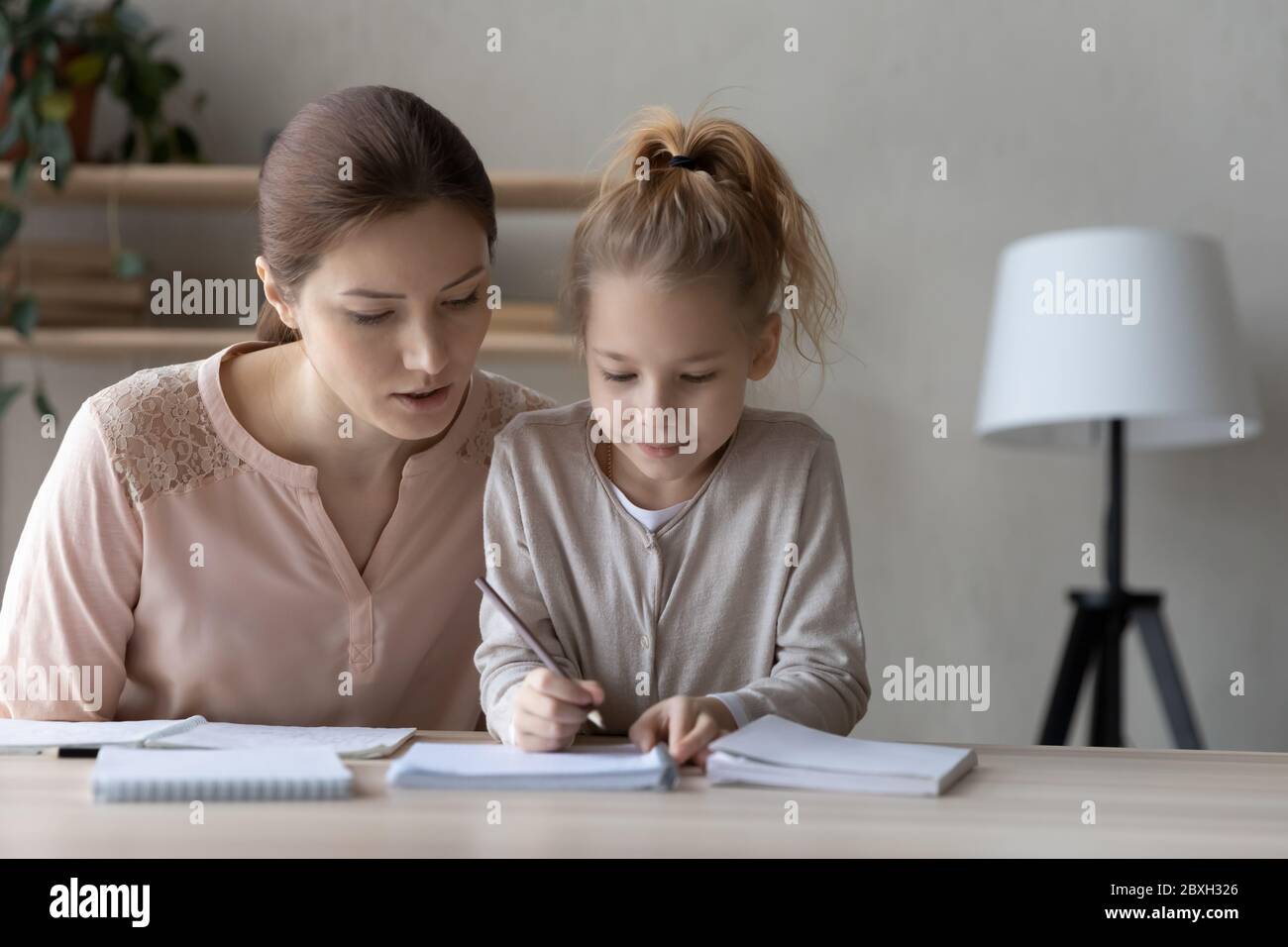 Young mother study prepare homework with small daughter Stock Photo - Alamy