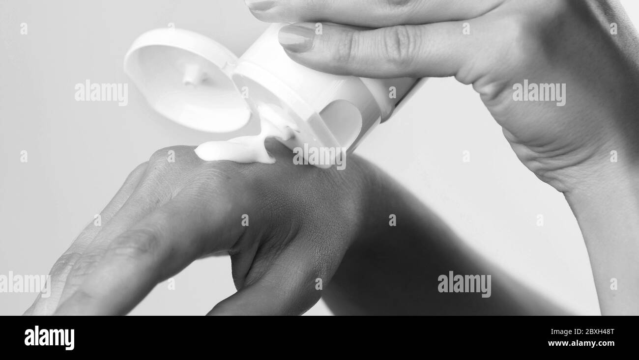 White hand cream being squeezed onto a woman's hand Stock Photo - Alamy