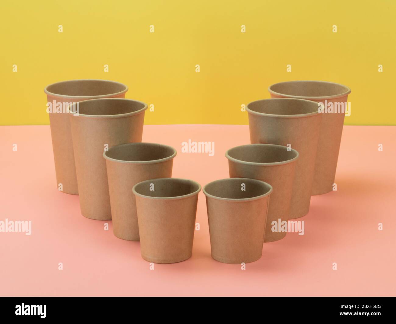 Eco-friendly paper cups in pink and yellow background. Bio ware Stock ...