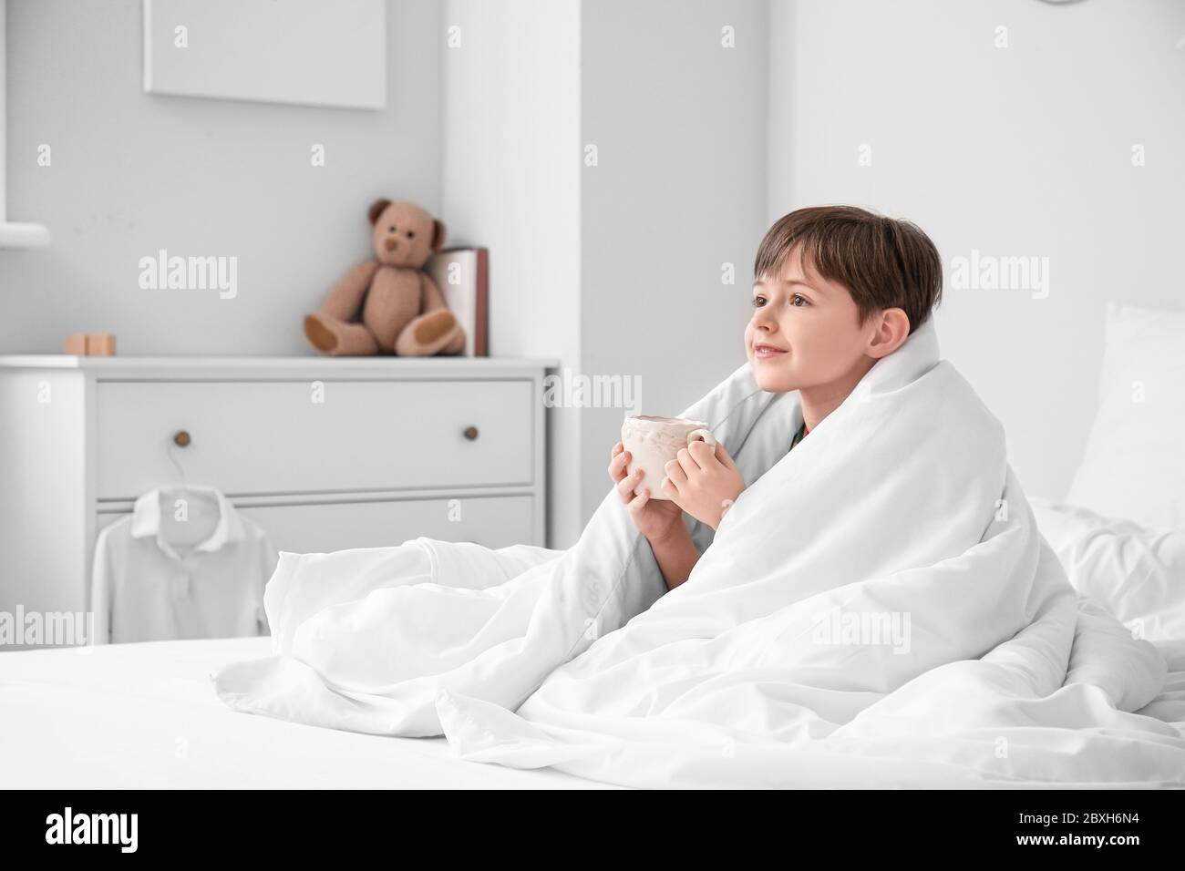 Morning of little boy drinking tea in bedroom Stock Photo - Alamy