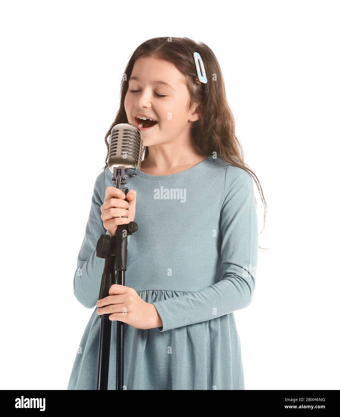 Cute little girl singing against white background Stock Photo - Alamy