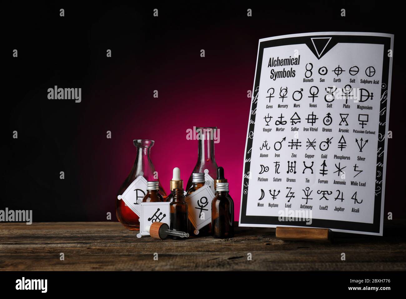 Potions with alchemical symbols on table Stock Photo - Alamy