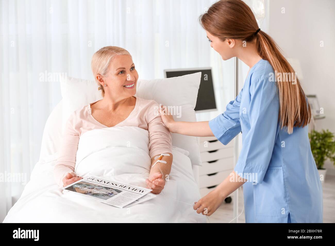 Female doctor working with patient in hospital room Stock Photo - Alamy