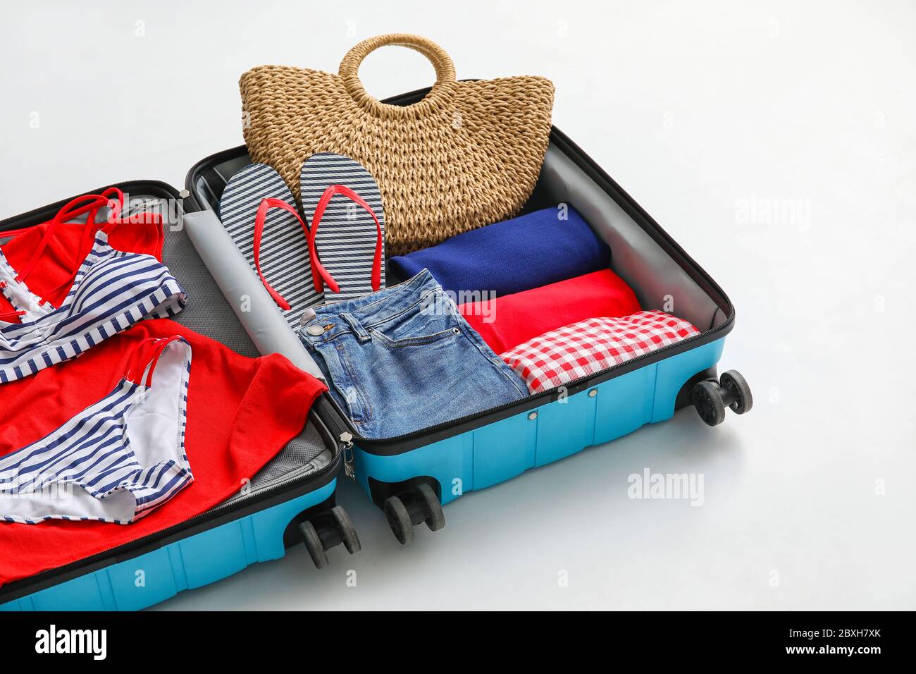 Open packed suitcase on white background Stock Photo - Alamy