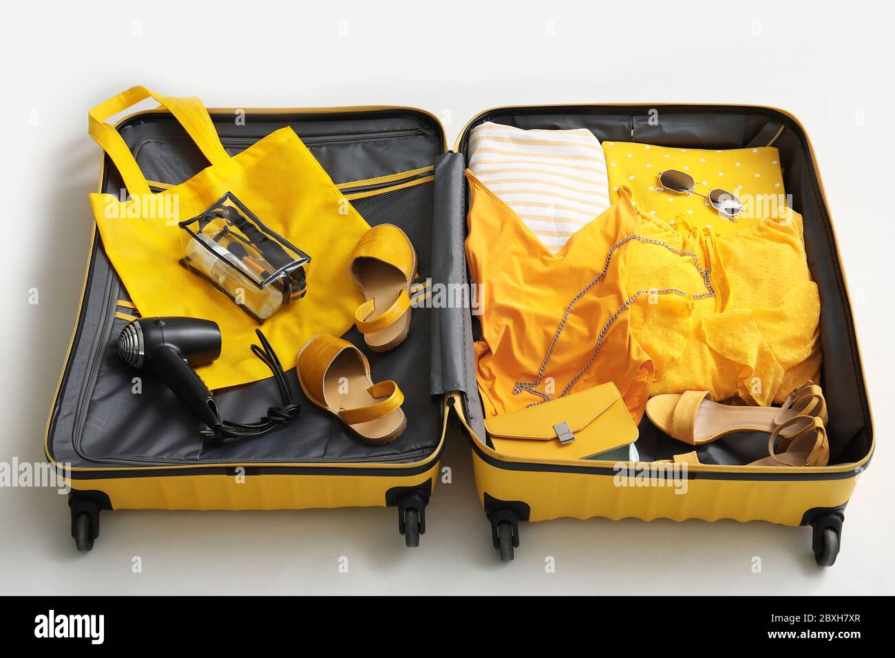 Open packed suitcase on white background Stock Photo - Alamy