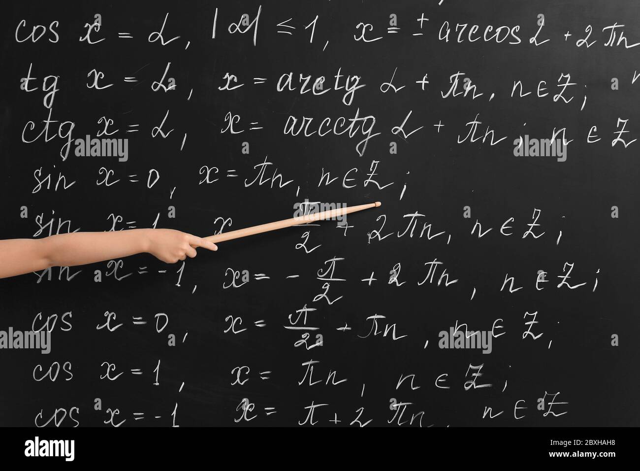 Cute little schoolgirl pointing at blackboard in classroom Stock Photo ...