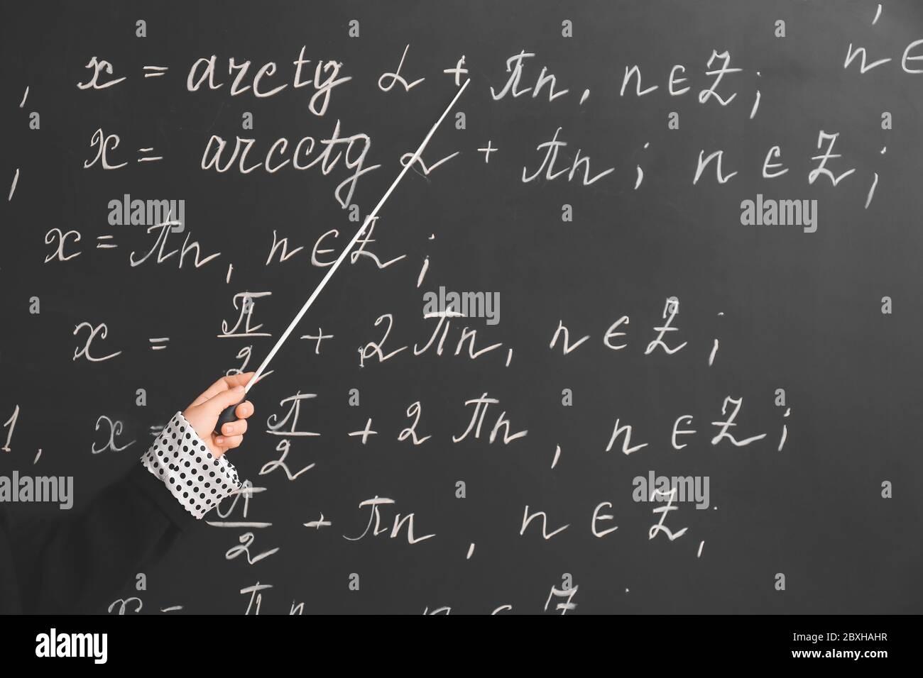 Cute little schoolgirl pointing at blackboard in classroom Stock Photo ...