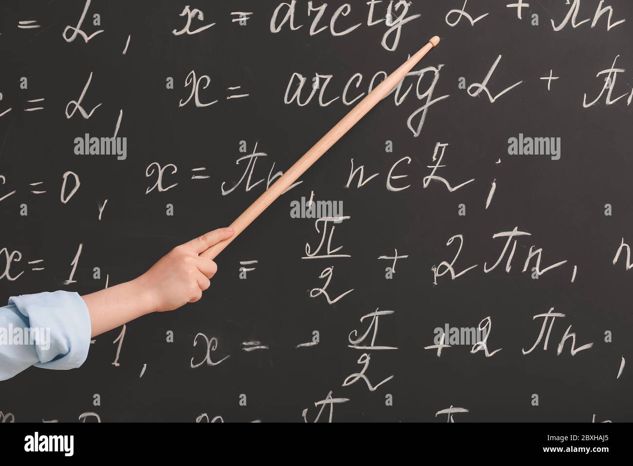 Cute little schoolgirl pointing at blackboard in classroom Stock Photo ...