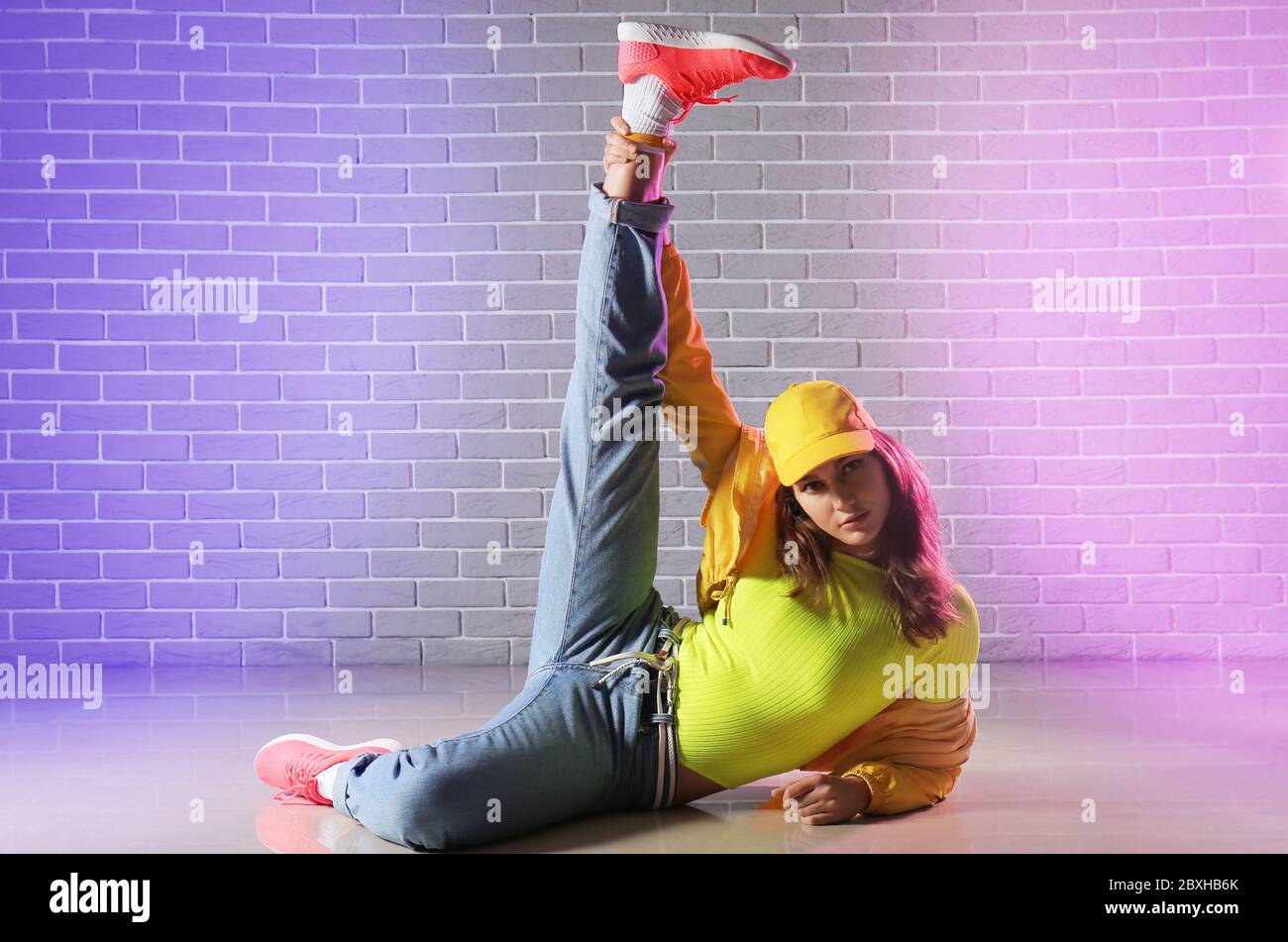 Beautiful female hip-hop dancer against brick wall Stock Photo - Alamy