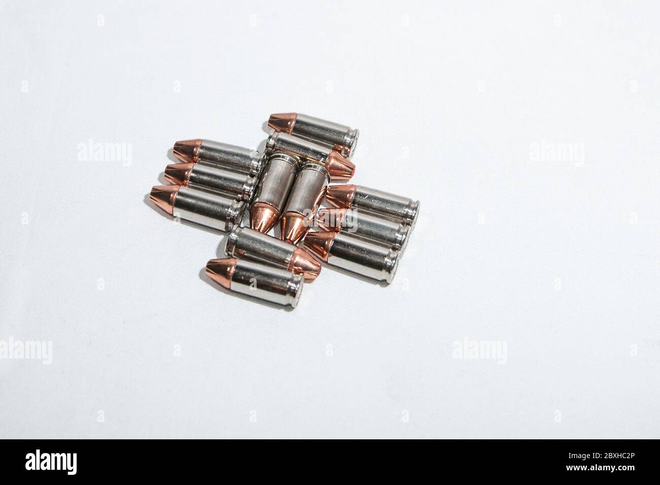 Several 9mm bullets laying on a white surface Stock Photo - Alamy