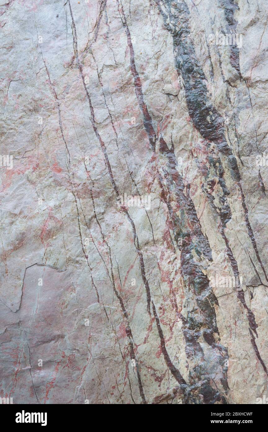 Mineral veins and stripes with pink and grey and metallic colours show ...