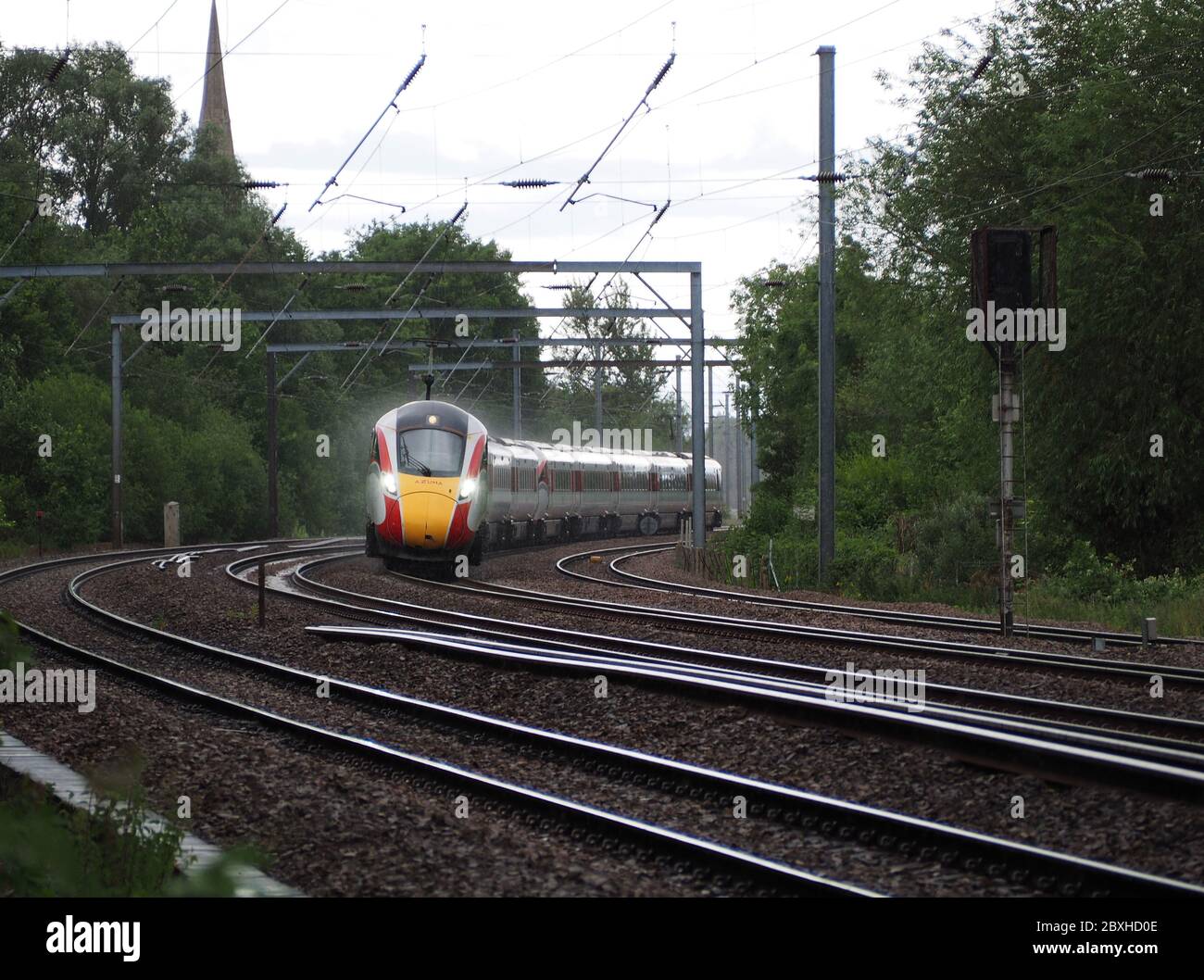 LNER Class 800 Azuma passes Offord Cluny in the rain on the East Coast Main Line, Cambridgeshire ...