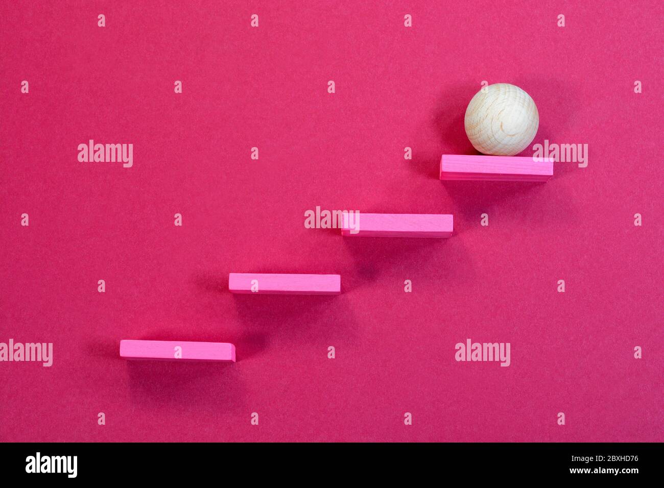 Leadership ball climbing the steps to the top Stock Photo - Alamy