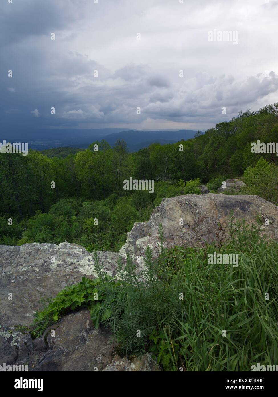 The storm clouds are parting and the sun shines through onto the land ...