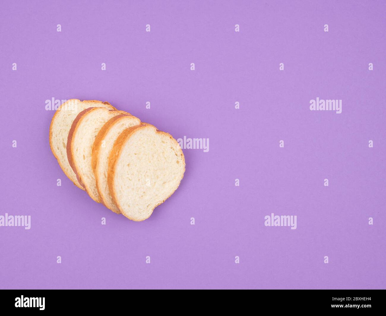 Sliced white bread on a purple background Stock Photo - Alamy