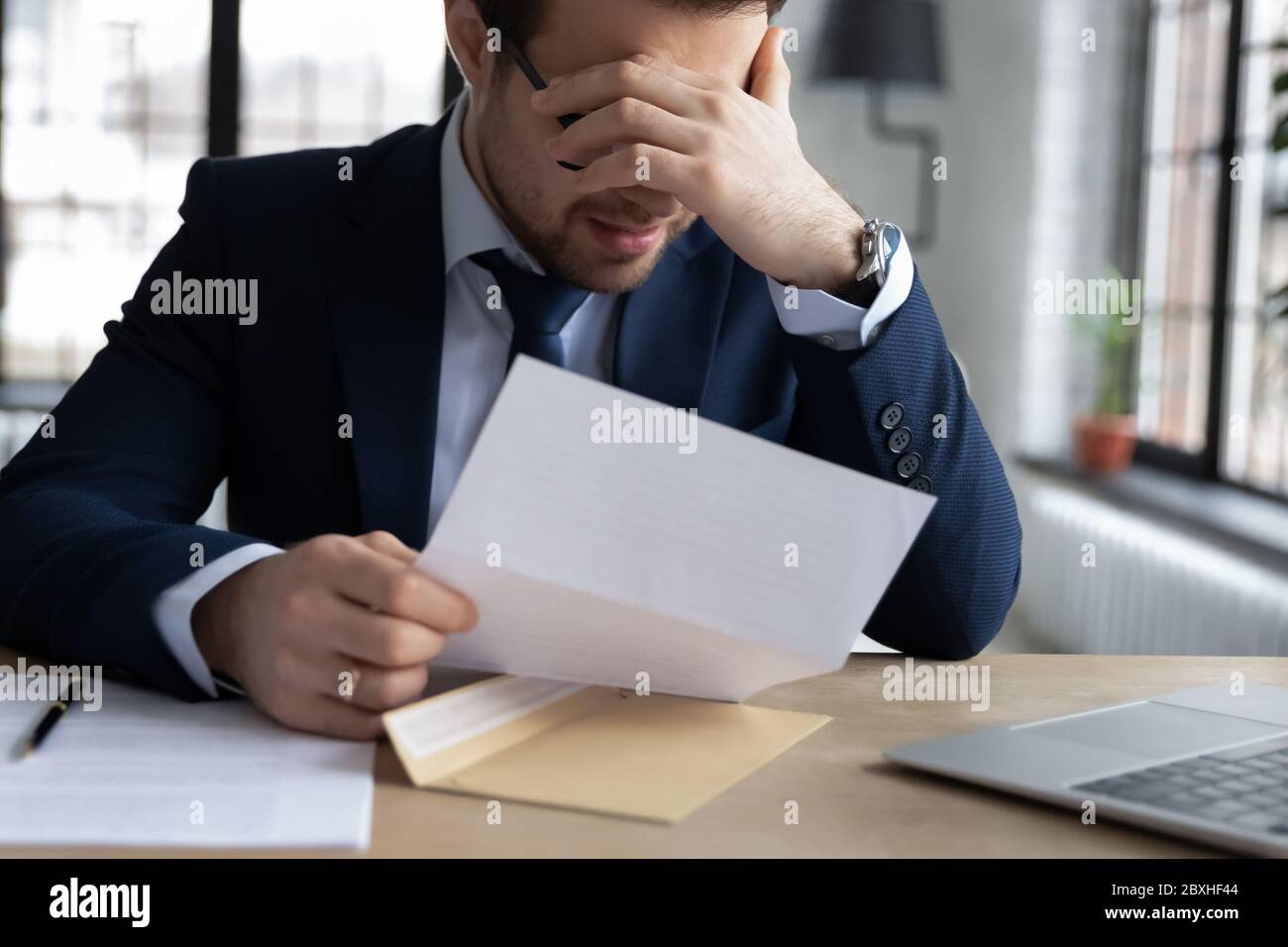 Upset male employee distressed by postal letter Stock Photo - Alamy