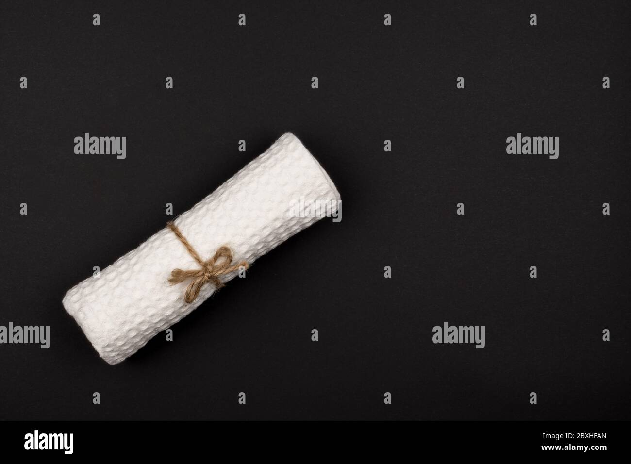 Tied with rope and a towel roll on a black background Stock Photo - Alamy