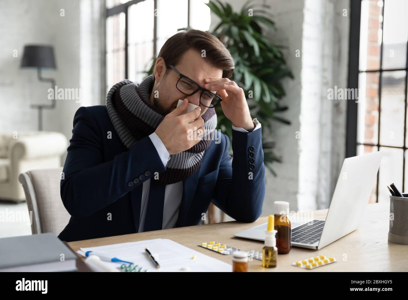 Sick male employee suffer from fever at workplace Stock Photo - Alamy