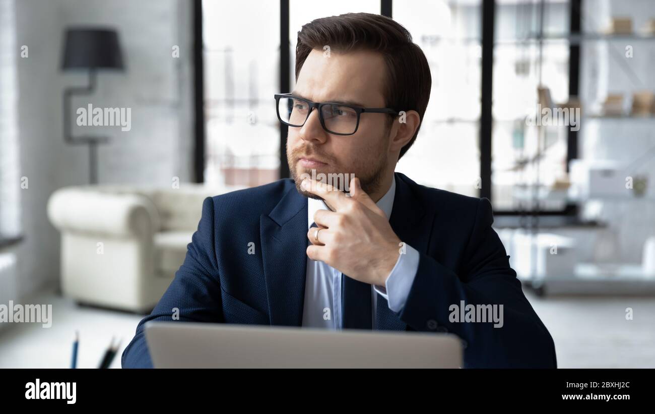 Pensive male boss look in distance thinking pondering Stock Photo - Alamy