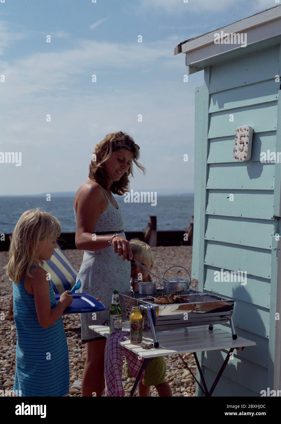Family cooking outside beachhut Stock Photo - Alamy