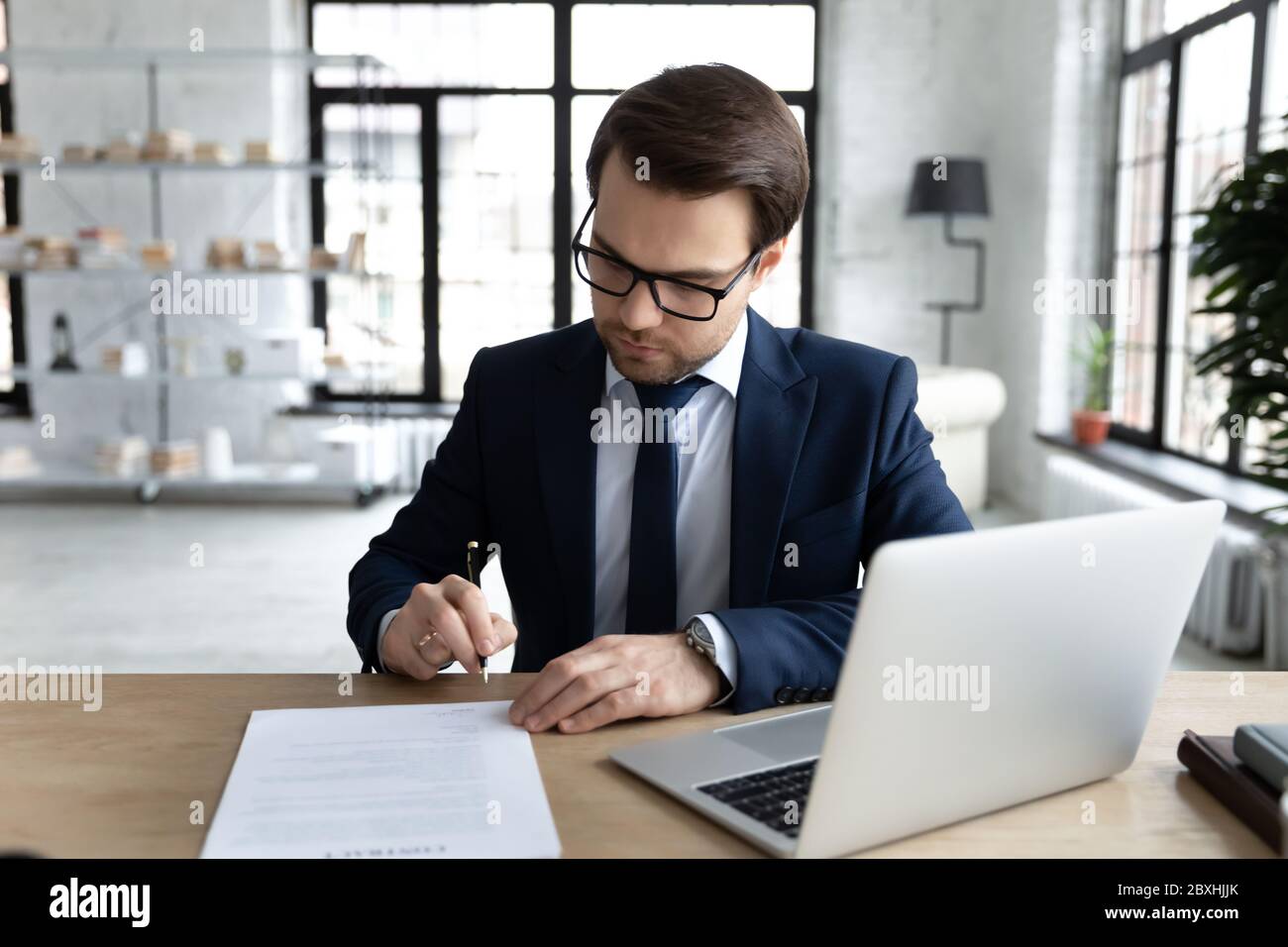 Serious businessman sign paper contract in office Stock Photo - Alamy