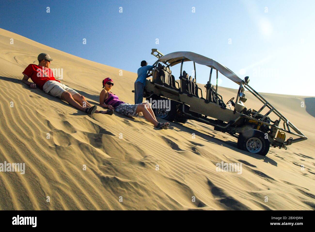 ICA, PERU - JULY 6, 2010: Sand dune buggy parked on a dune and group of ...