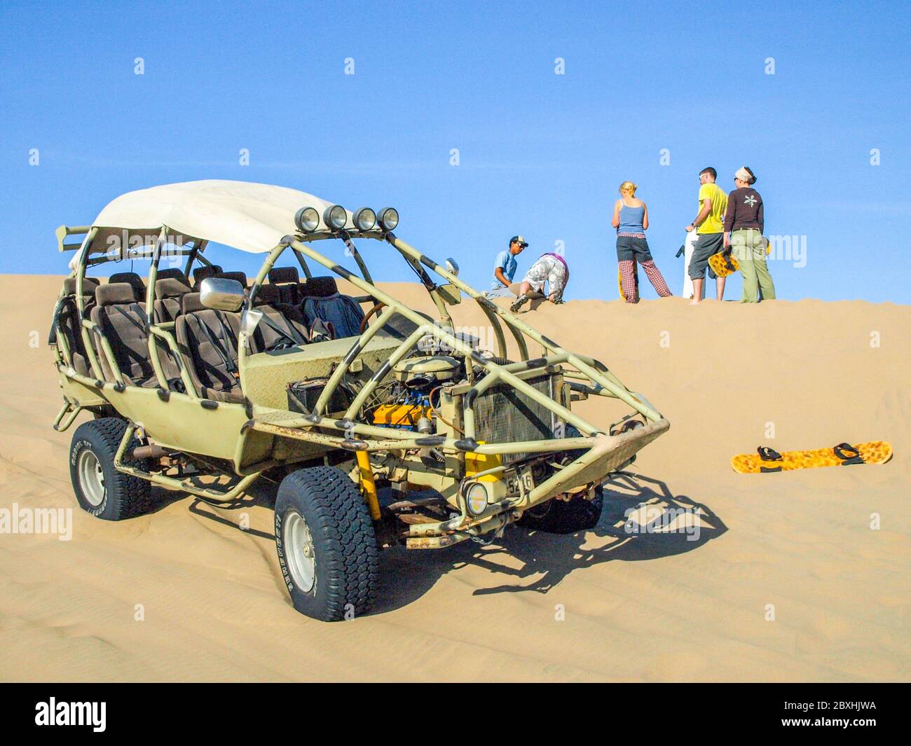ICA, PERU - JULY 6, 2010: Sand dune buggy parked on a dune and group of ...