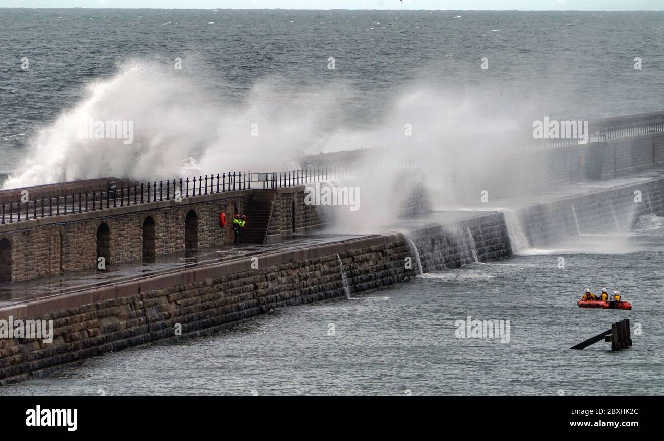 Rescue teams make their way back along Tynemouth pier wall after ...