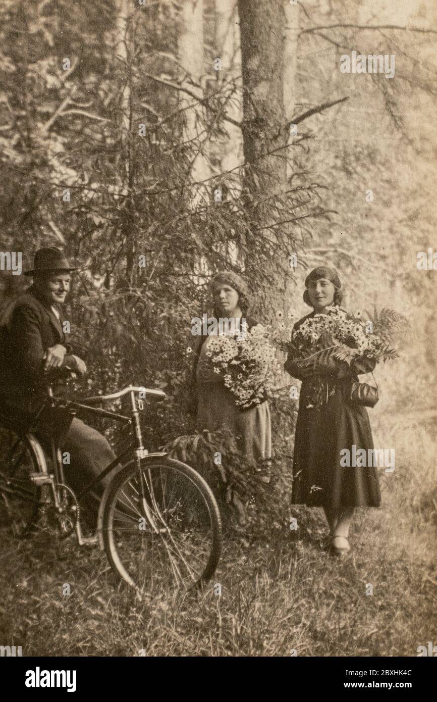 Germany - CIRCA 1930s: Man on bicycle talking with two woman in forest ...