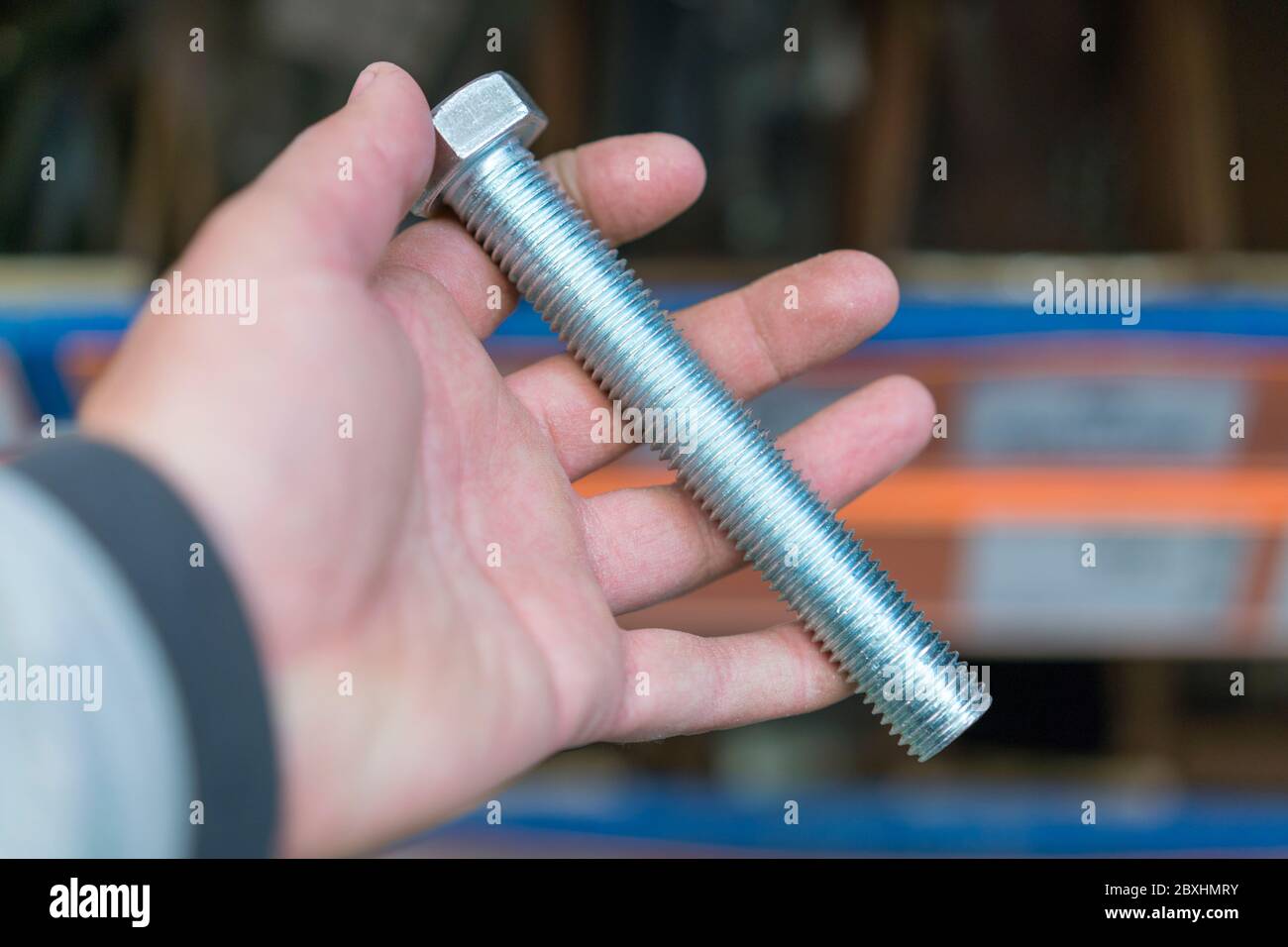 hand holds an iron bolt. repair concept. close-up Stock Photo - Alamy