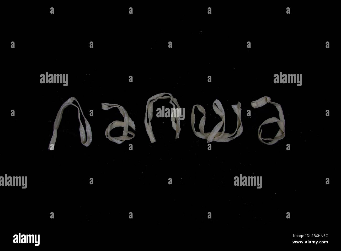 lettering LAPSHA (noodles in russian), made of noodles on black ...