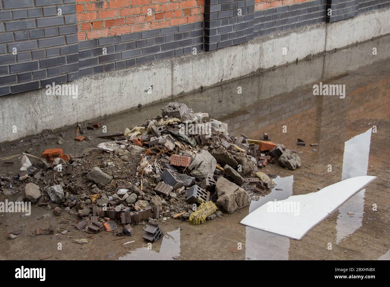 Construction debris lies in a puddle. Remnants of materials after home ...