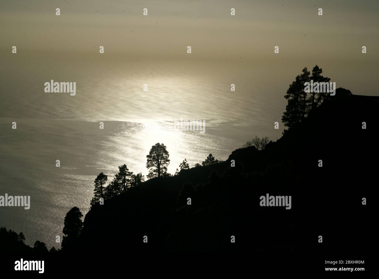 ocean behind a cliff in the backlighting Stock Photo - Alamy