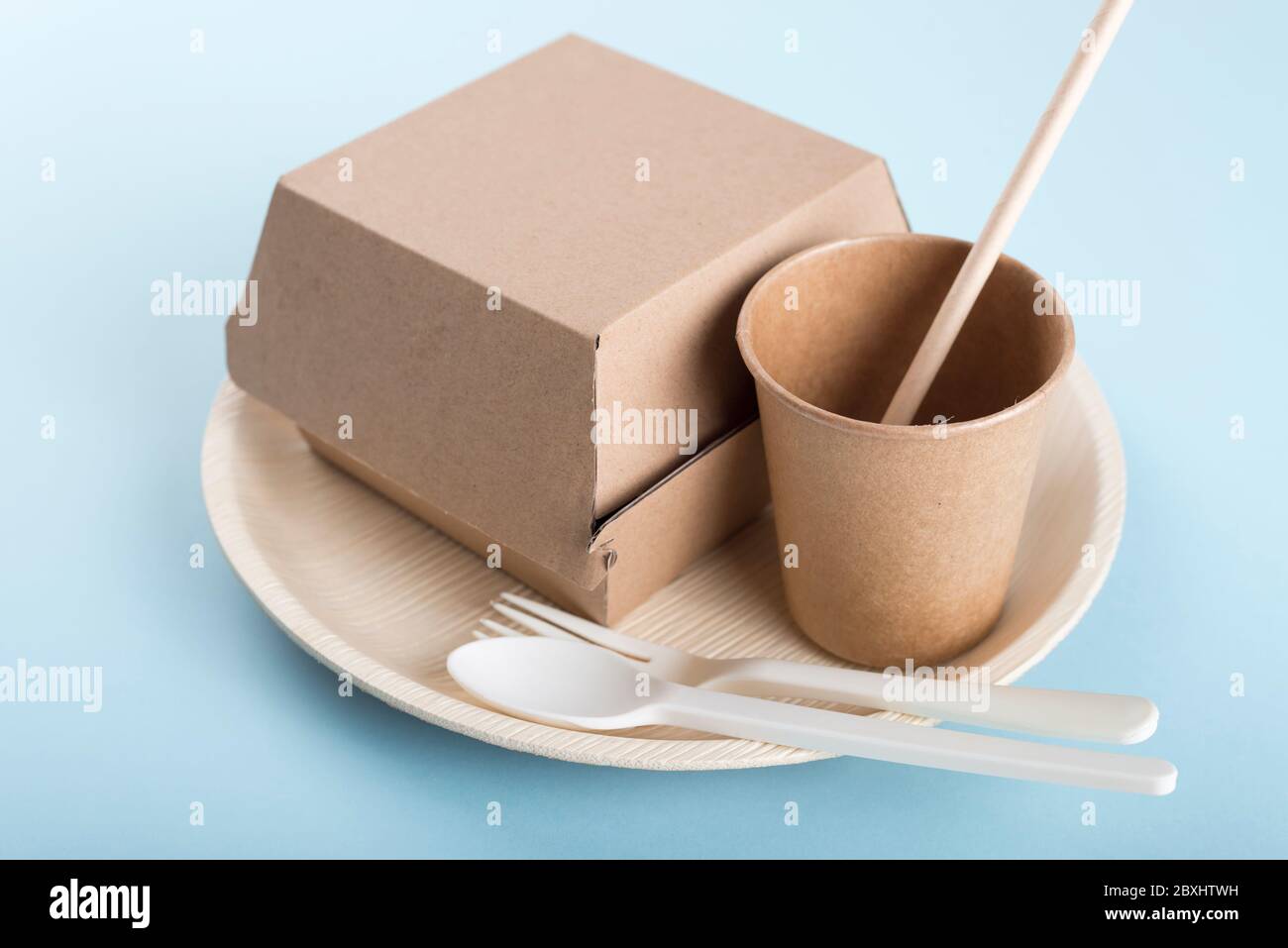 Biodegradable disposable dishes on light blue background. Recycling ...