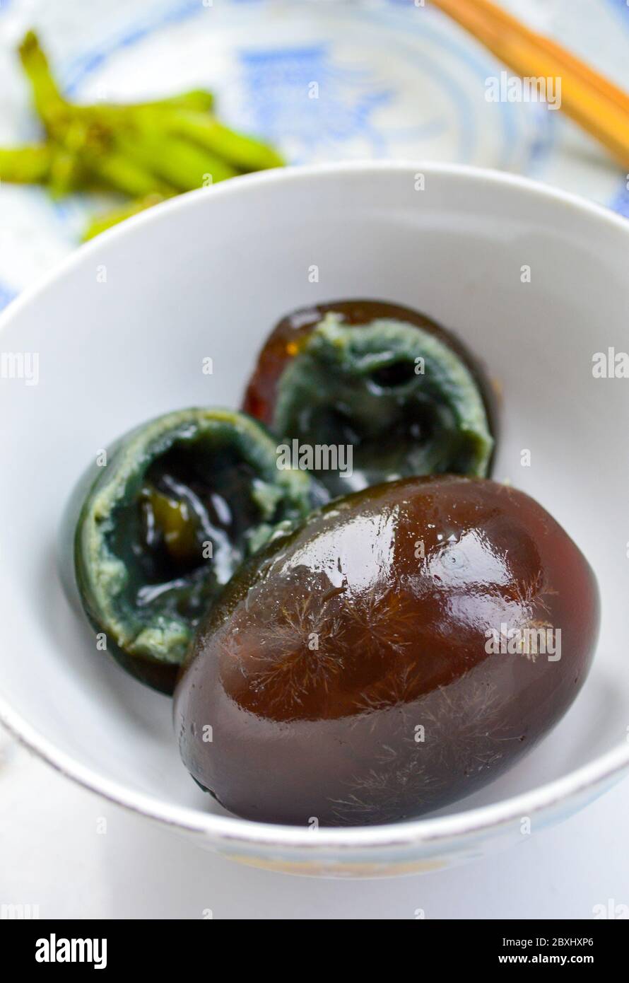 Chinese Century Eggs in White Bowl. One Egg Cut in Half Shows Black ...
