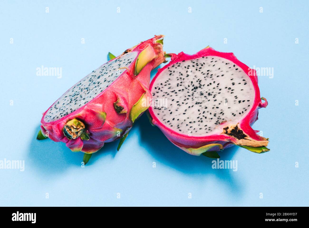Cut pitaya on a blue background. Dragon fruit of the Hylocereus undatus ...
