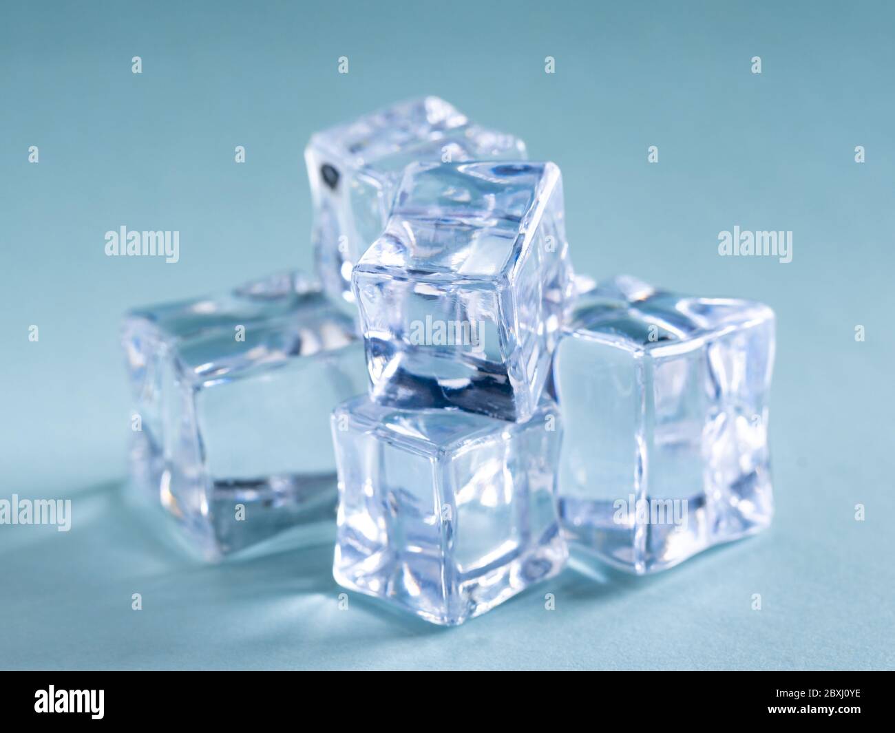 Pile of plastic ice cubes isolated on blue background Stock Photo - Alamy