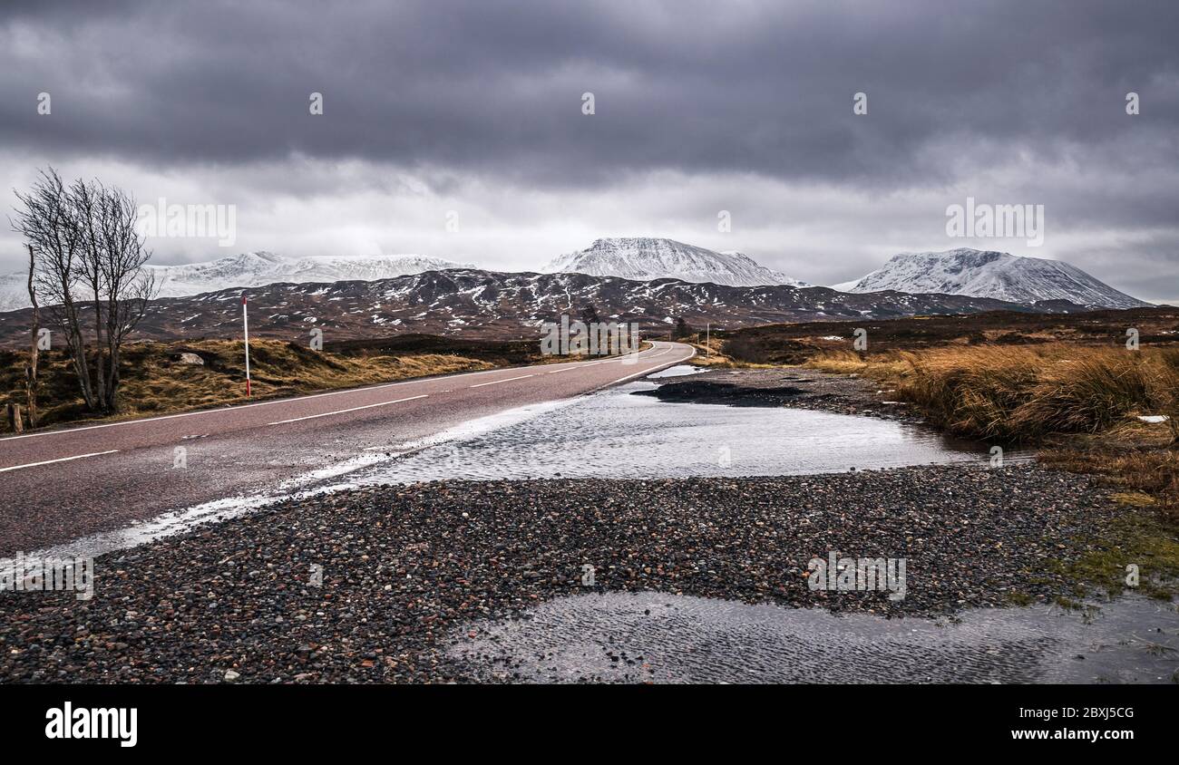 An empty road running through Rannoch Moor with sormy clouds on the ...