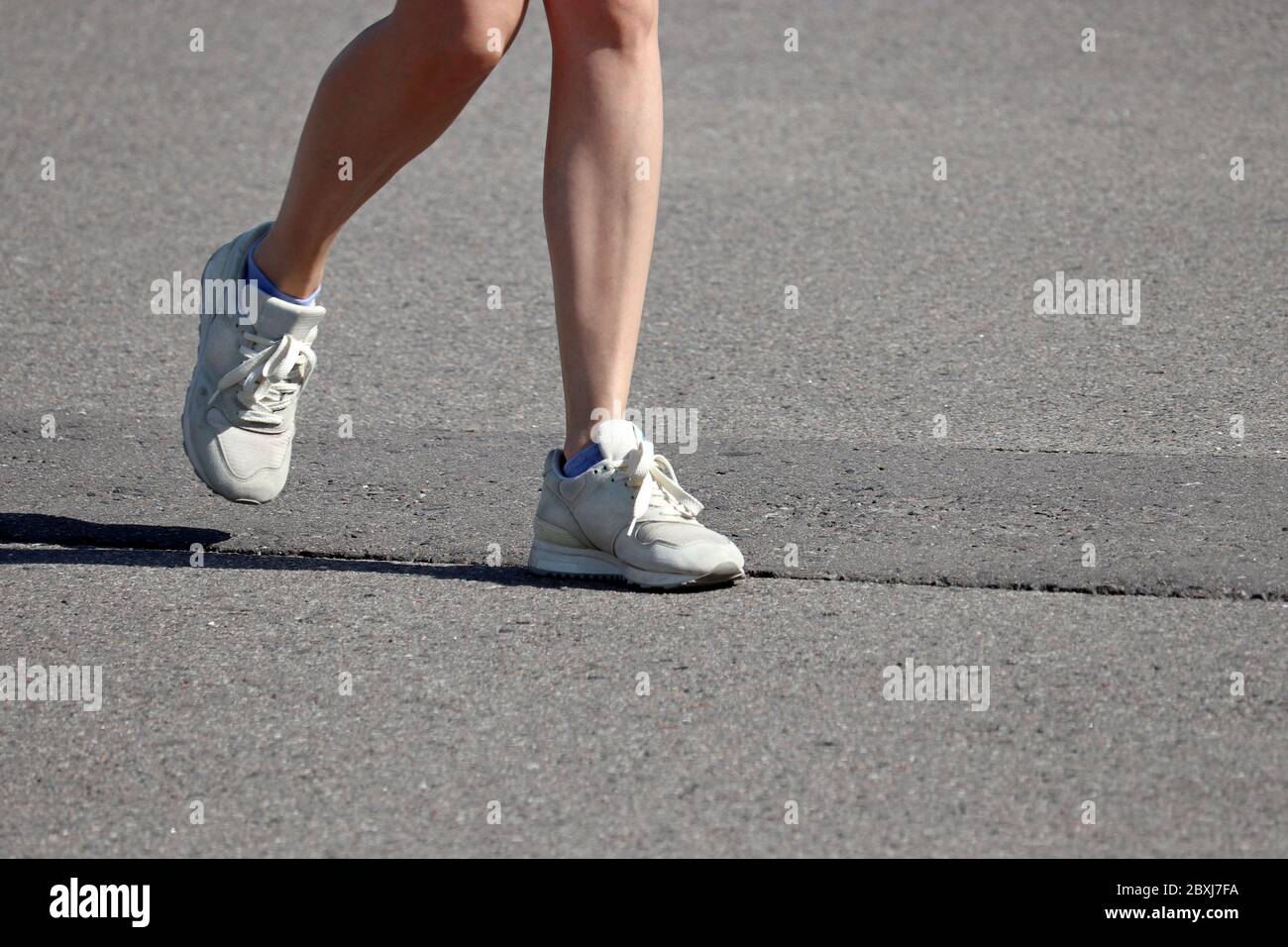 Slim girl running on a street, female legs in sneakers. Concept of ...